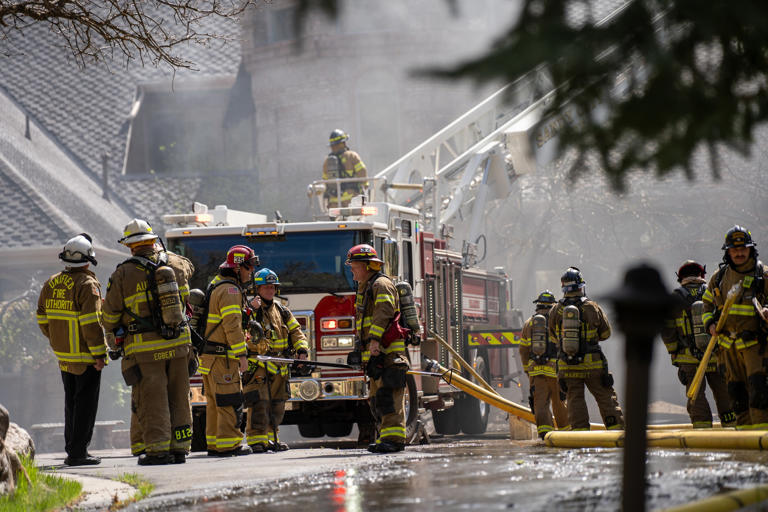 Firefighters battle house fire in Sandy, smoke and flames visible