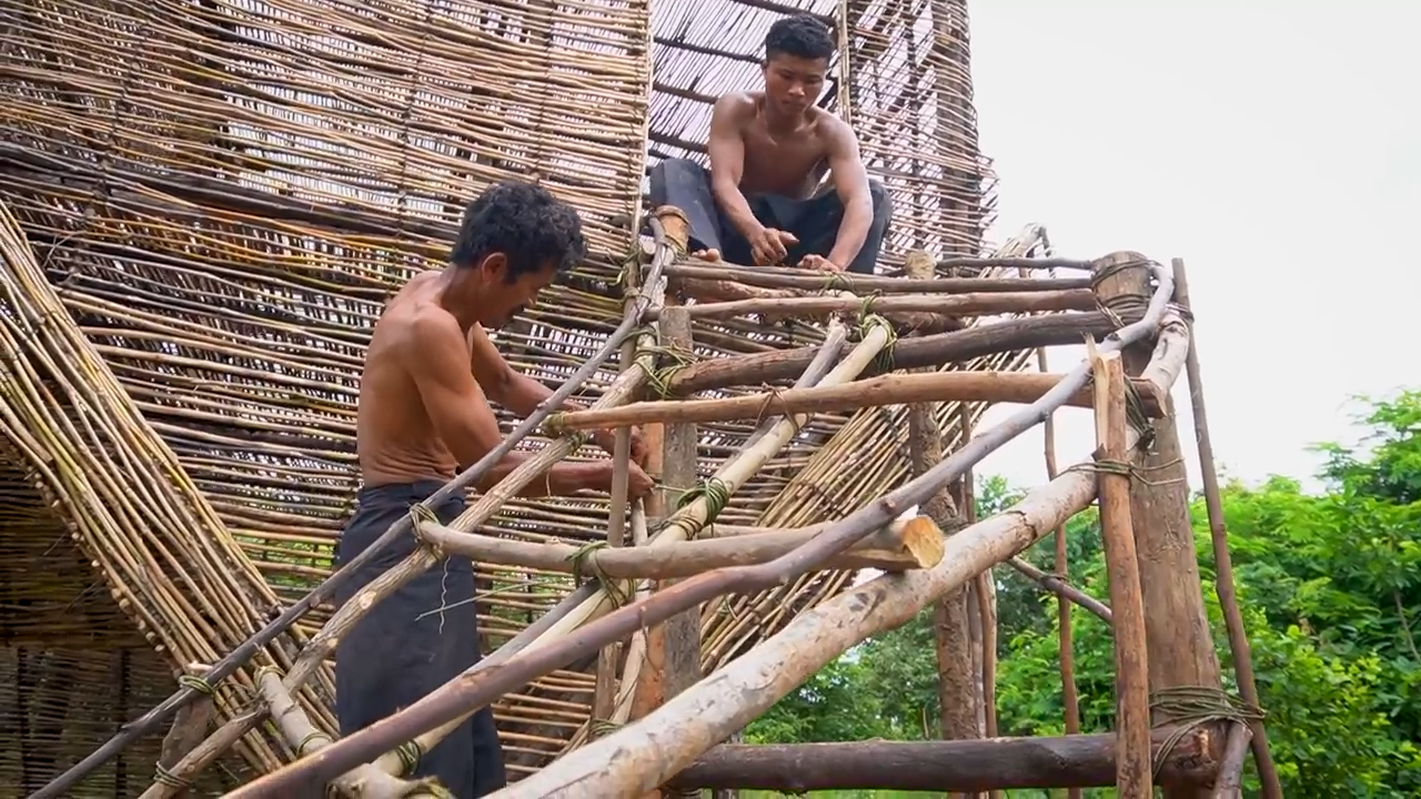 Watch these guys work until exhaustion creating a large bamboo shelter ...