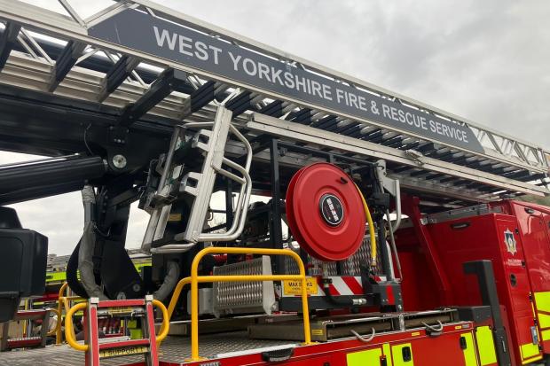Aerial appliance used to battle building fire which spread to roof