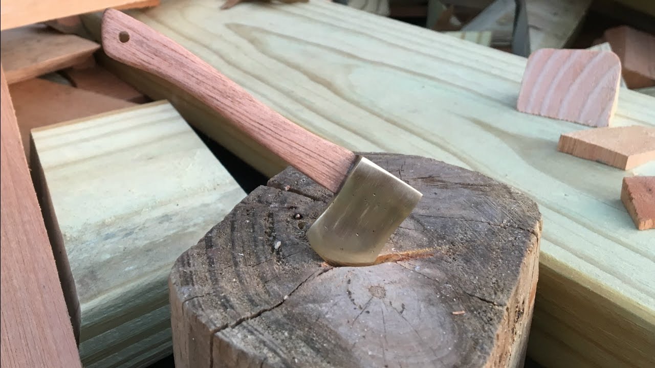 Sandcast a brass axe keychain from molten metal
