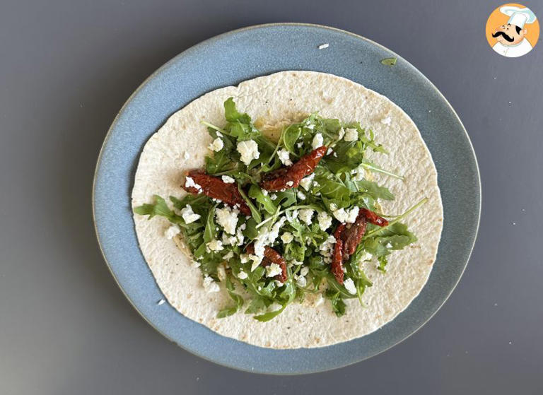 Mediterranean wrap stuffed with hummus, arugula, peppers and feta