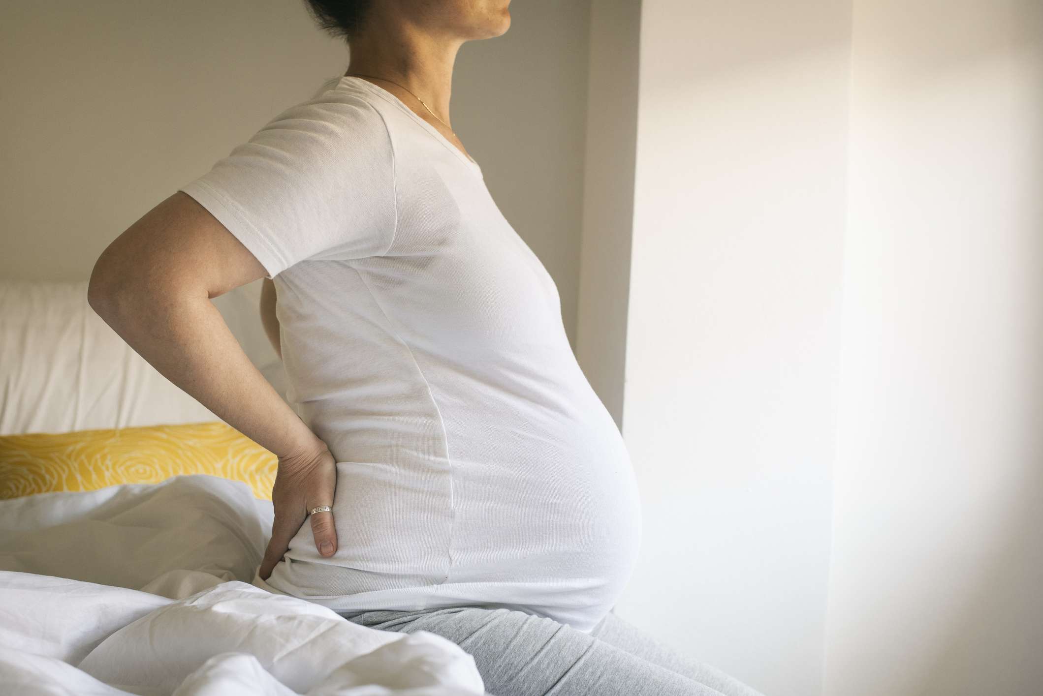 What is causing my lower back pain and swelling in legs and feet?