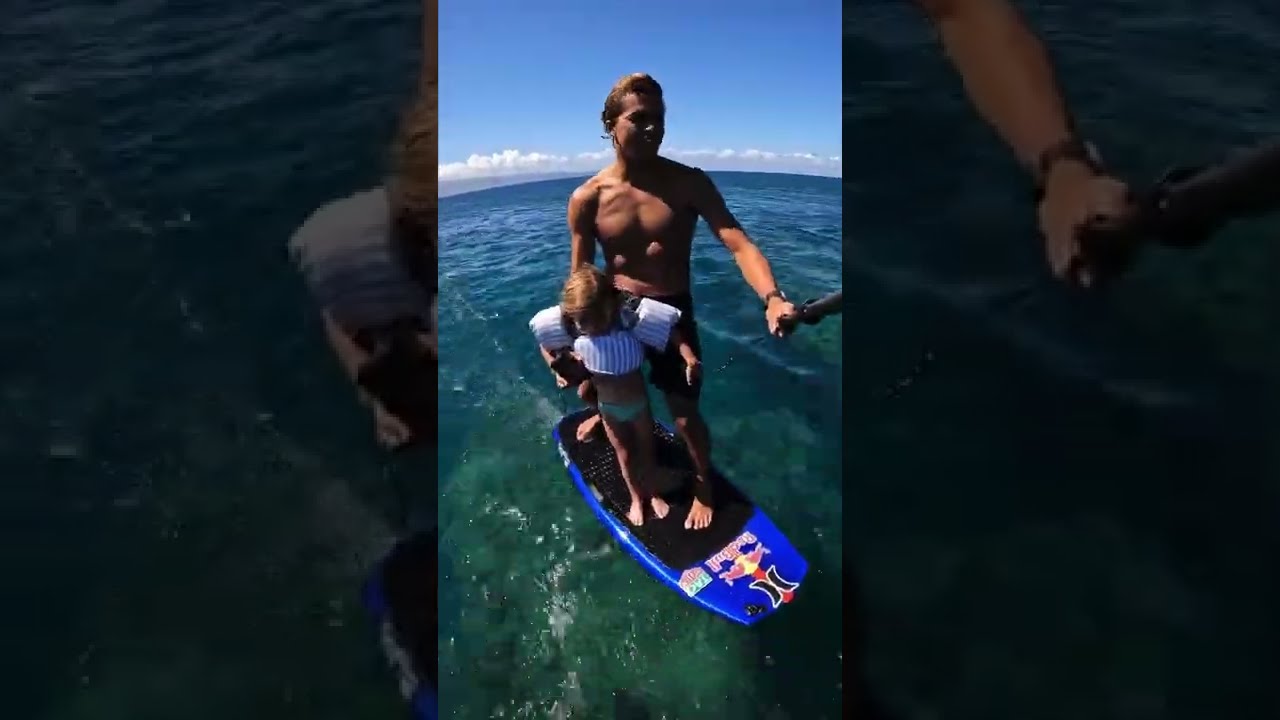 Professional surfer takes excited young children out to catch waves