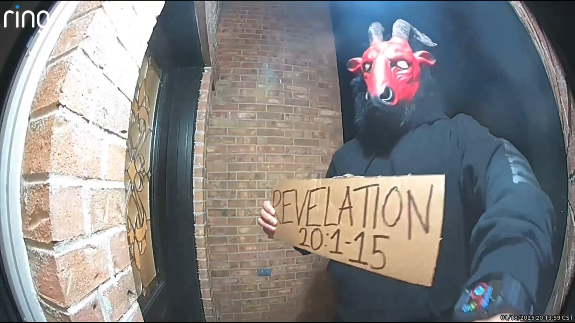 Man wearing satanic mask, holding sign with apocalyptic Bible verse ...