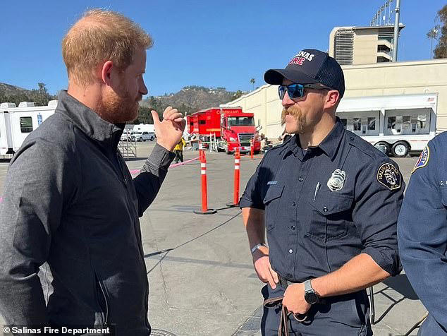 Prince Harry poses for pictures with LA fire crew and therapy dogs