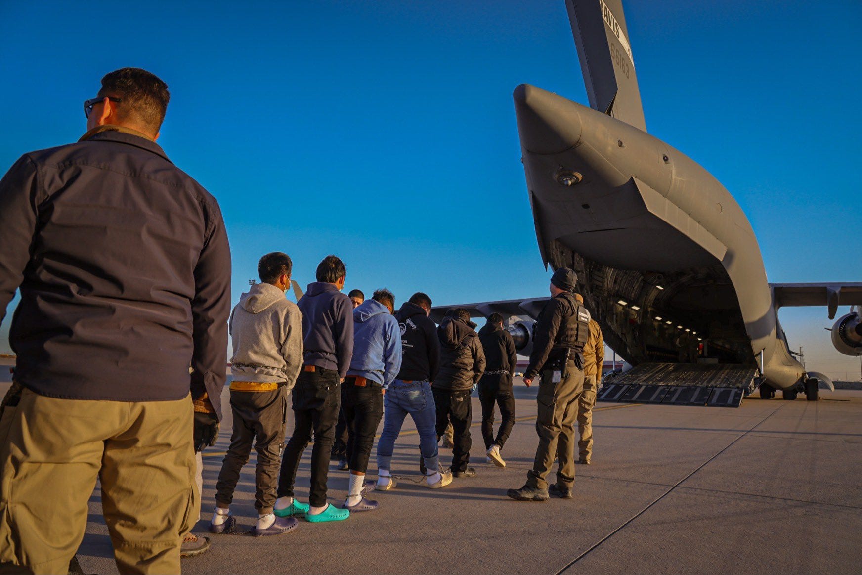 White House official releases photos of migrants boarding military ...
