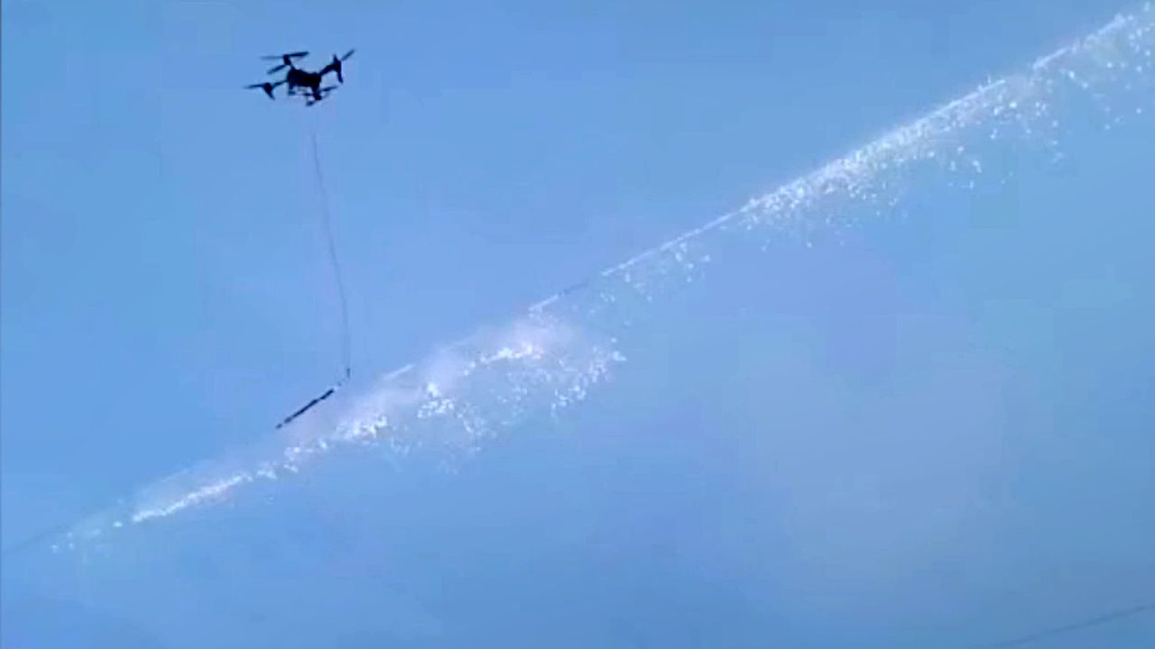 Drones use de-icing sticks to whack ice and snow off power lines