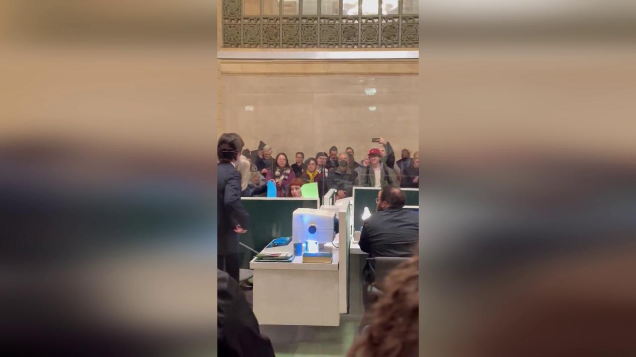 Severance cast pose in glass box at Grand Central Station in New York