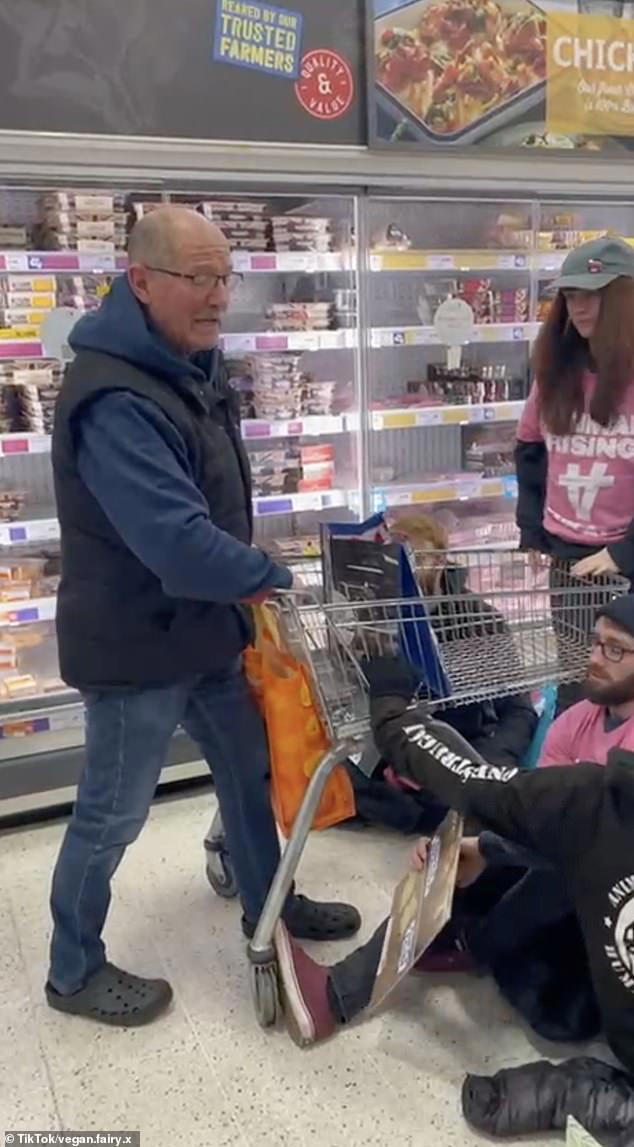 Moment angry shoppers try to barge Animal Rising activists out of way