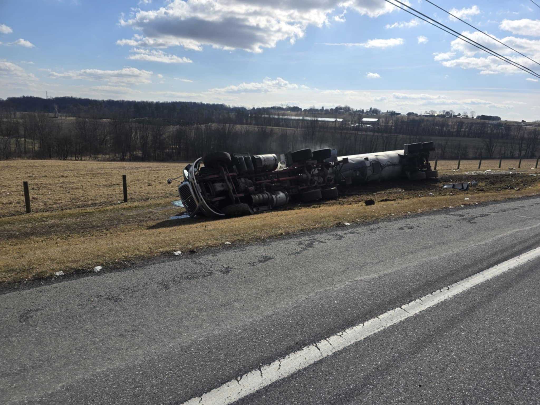 Tanker truck hauling liquid asphalt flips over