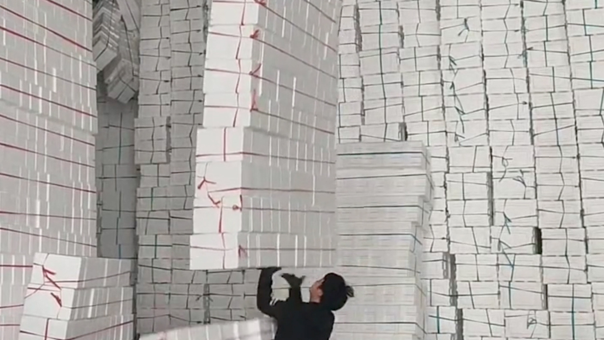 Worker handles tower of 28 foam boxes FOUR times taller than him