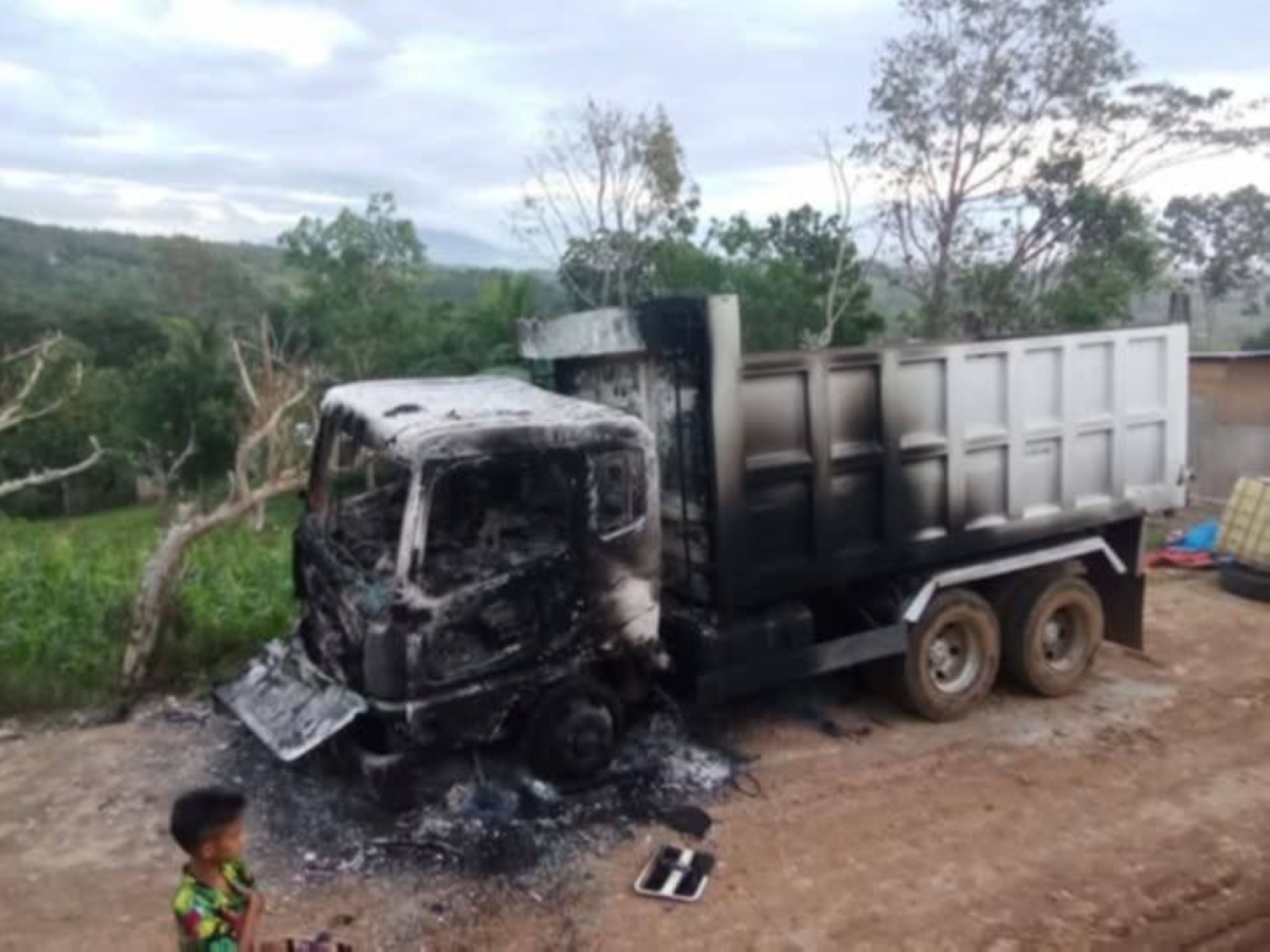 Armed men burn heavy equipment