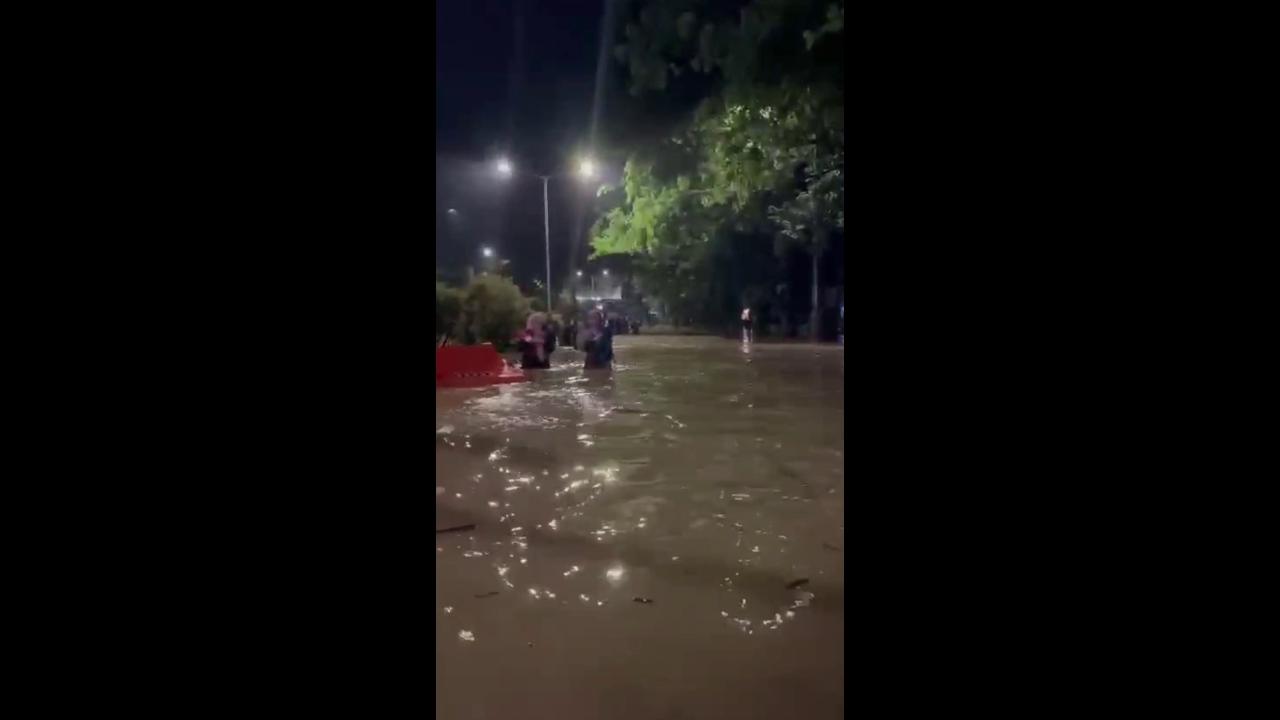 Locals wade through chest-deep floods in Indonesia