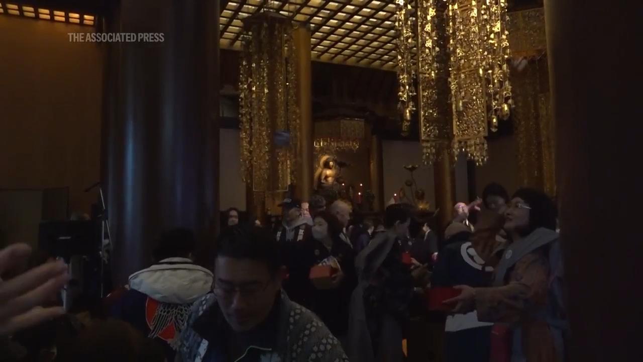 Hundreds reach out to catch lucky beans at Japan's annual festival