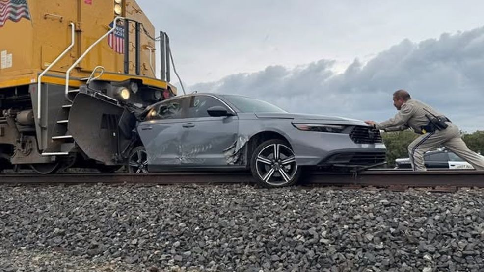 Honda stuck on railroad tracks after crash, hit by train, pushed ...