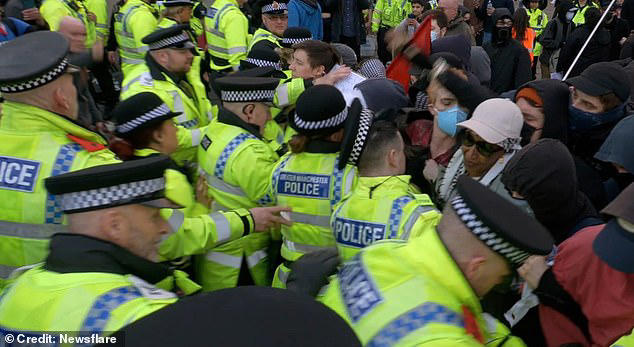 Moment protester flips cap off policeman's head at UKIP rally