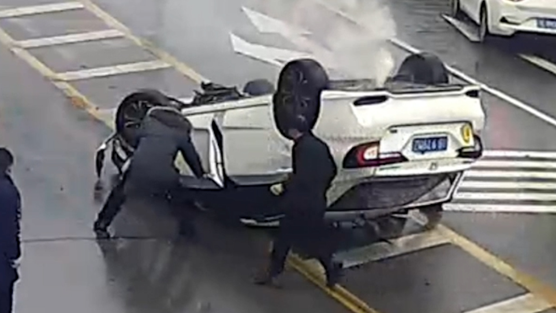 Passers-by rescue people trapped in overturned car in China's Chongqing