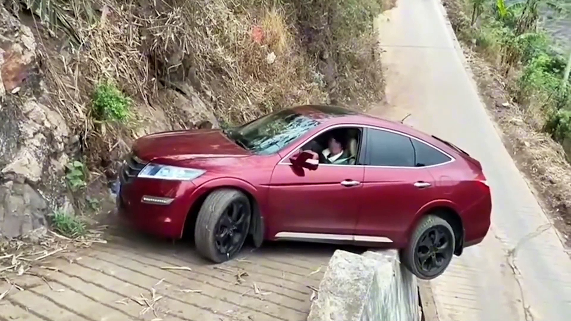 Driver's daring U-turn on narrow road leaves car teetering over steep edge