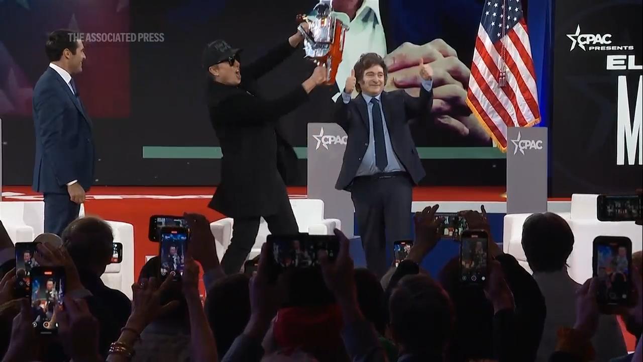 Elon Musk waves chainsaw on stage at CPAC