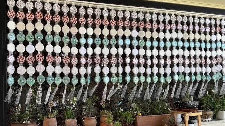 Upcycle old jar lids into a stunning backyard privacy screen