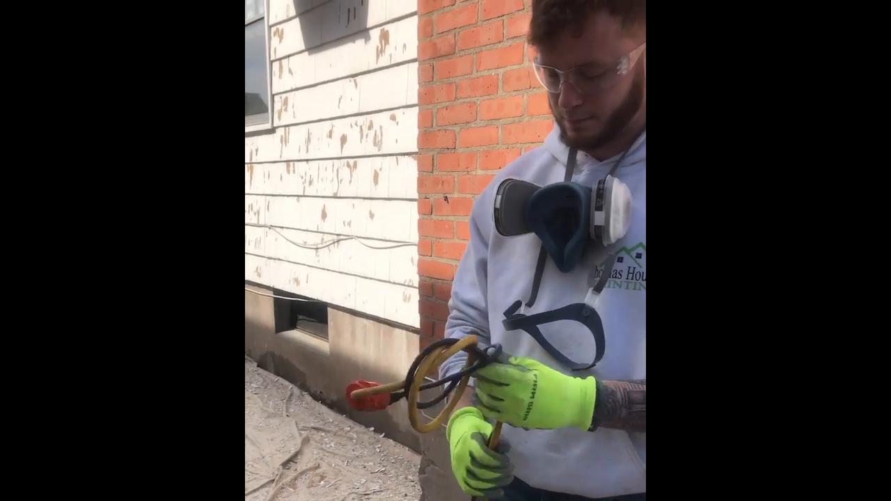 Working beside brick wall with electric sander