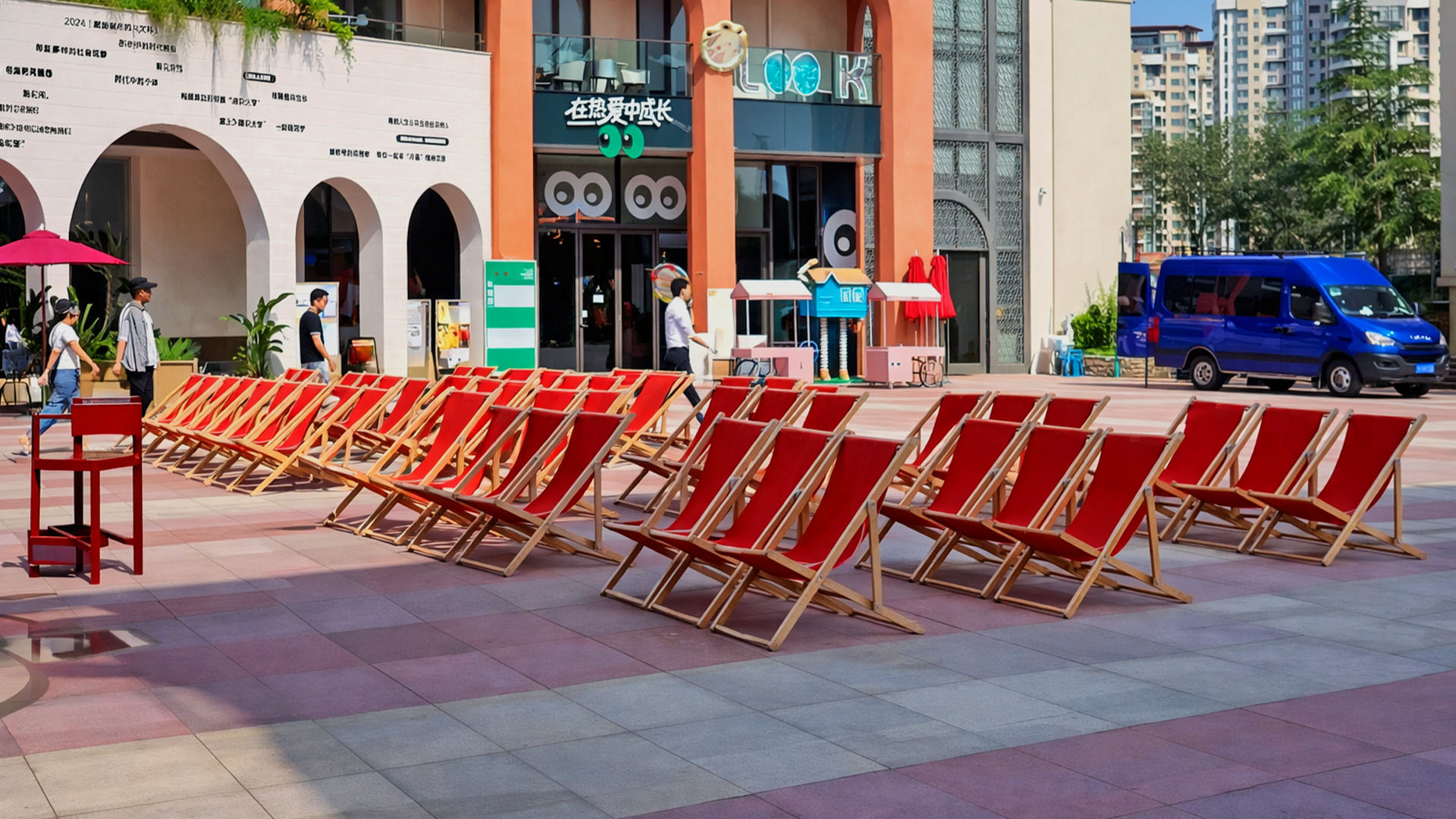Urban gathering space with red chairs near cafes and shops