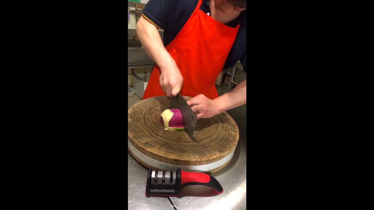 Cracking open green coconut with heavy cleaver on wooden board creating ...