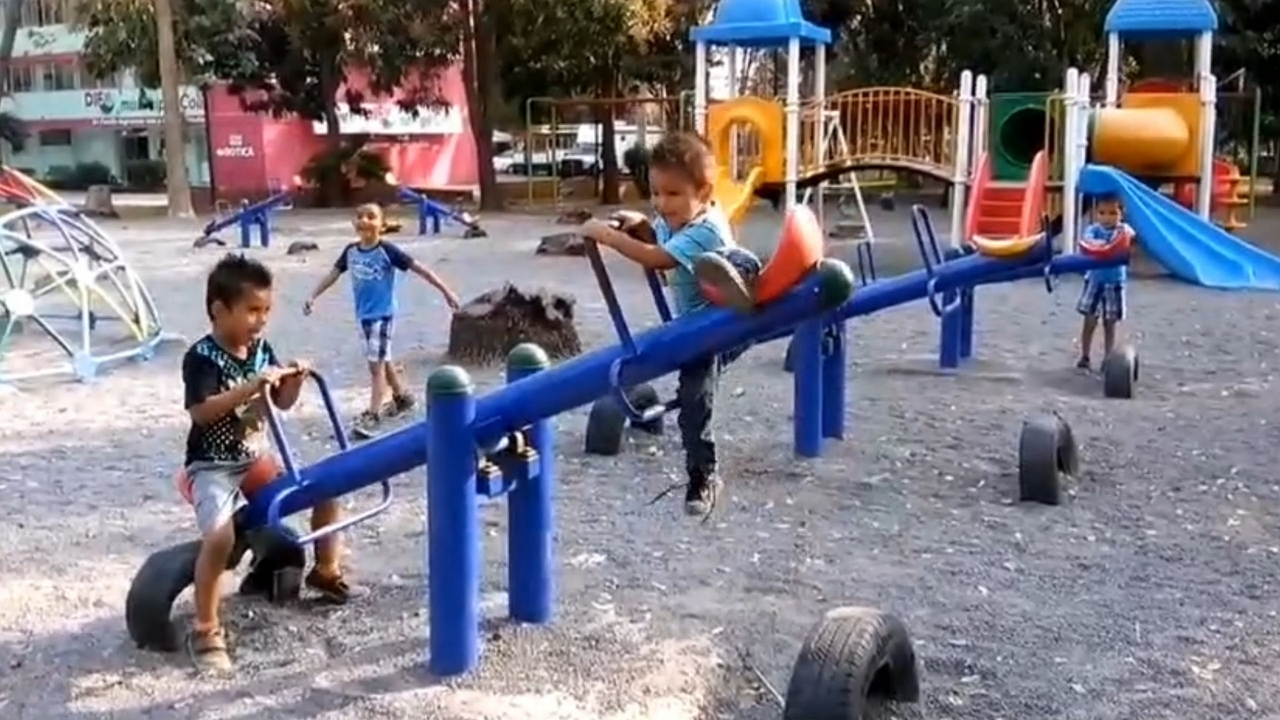 Older brother helps sibling during seesaw play in Colima, Mexico