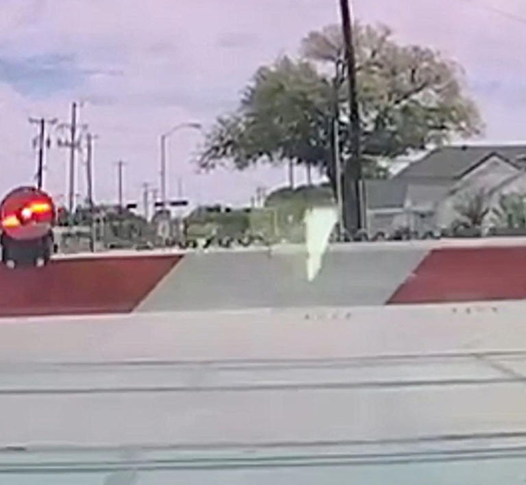 Terrifying moment self-driving Tesla crashes through railroad gate as ...