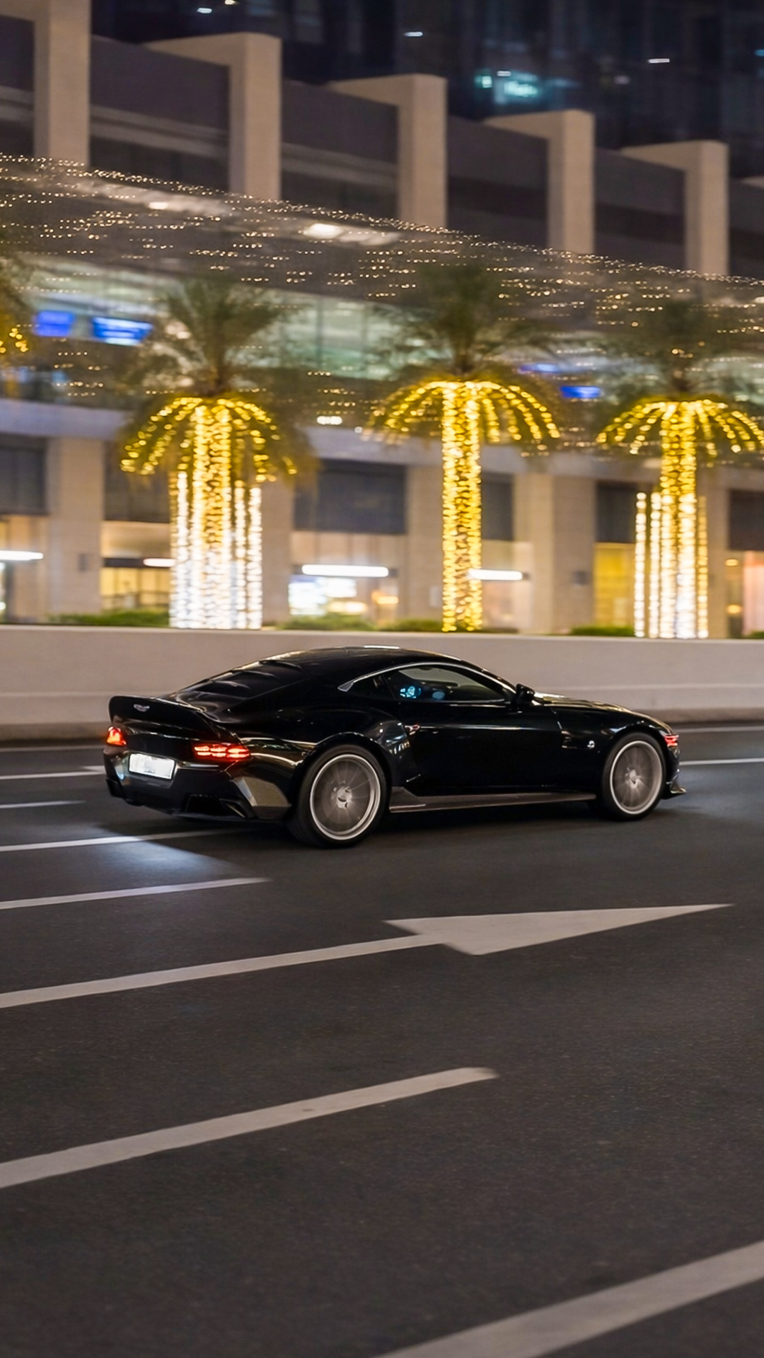 Aston Martin Valour on road with city lights