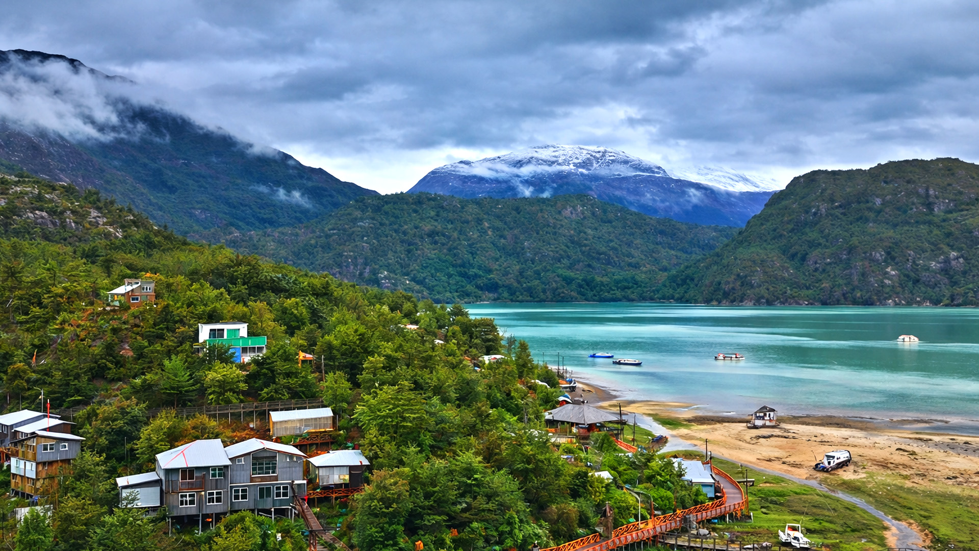 Un pequeño pueblo junto a un lago con colinas verdes