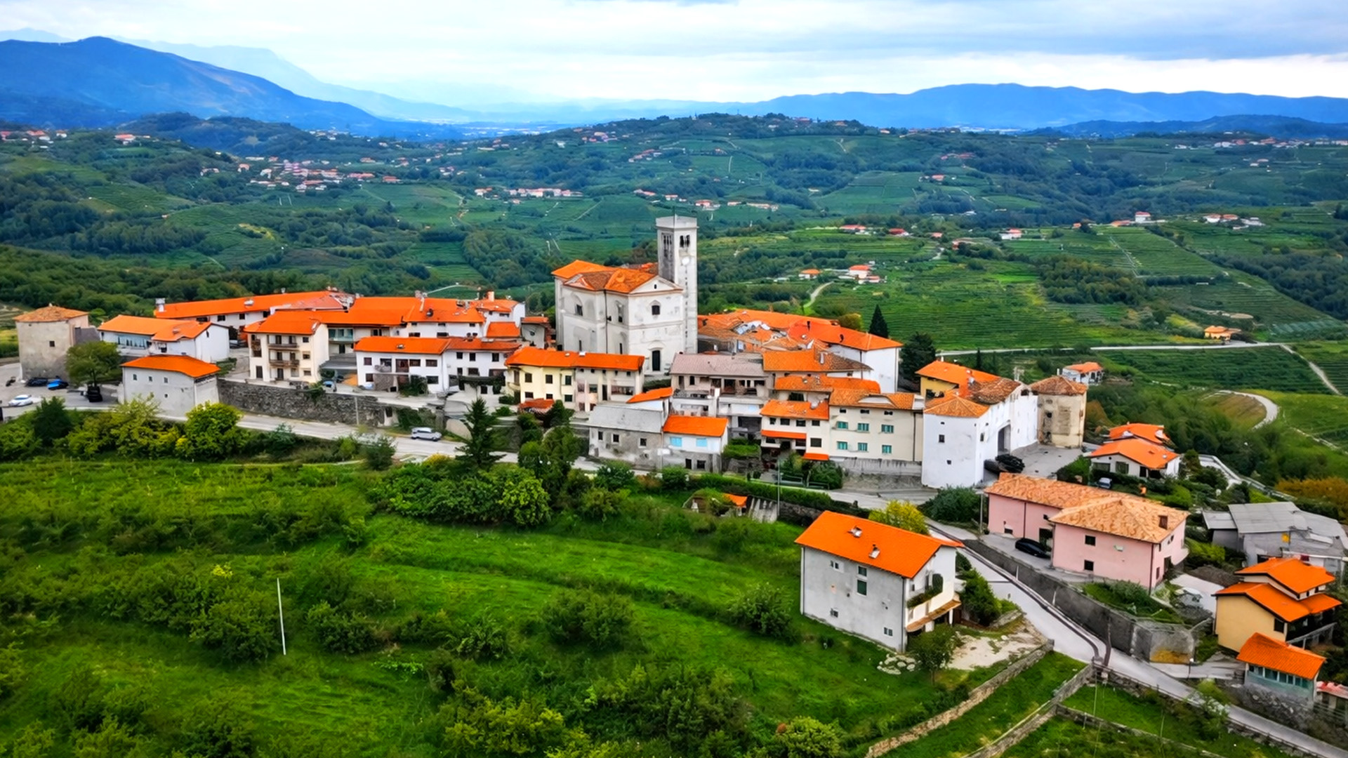 Un villaggio con una chiesa solitaria tra dolci colline
