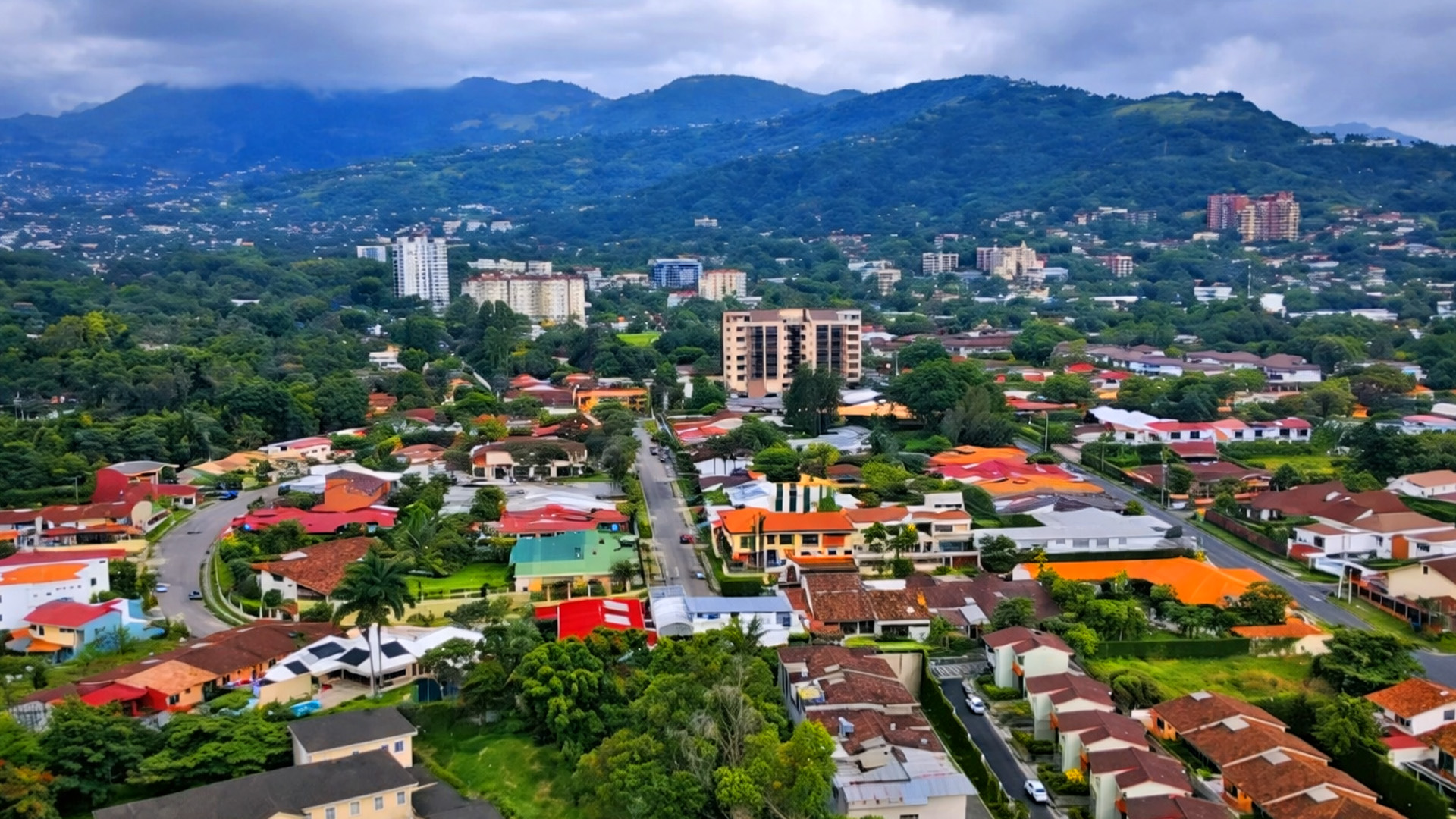 A city spread across a valley surrounded by green hills