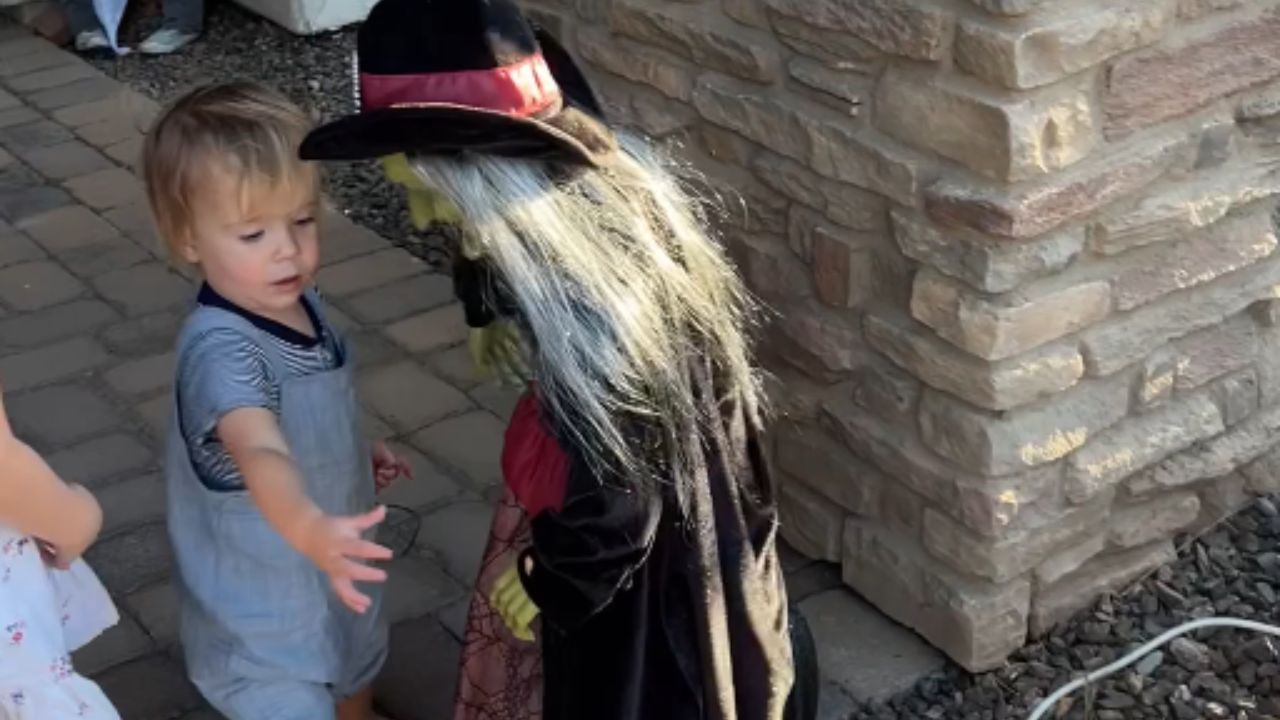Little one overcomes his fear by toppling the Halloween witch out of ...