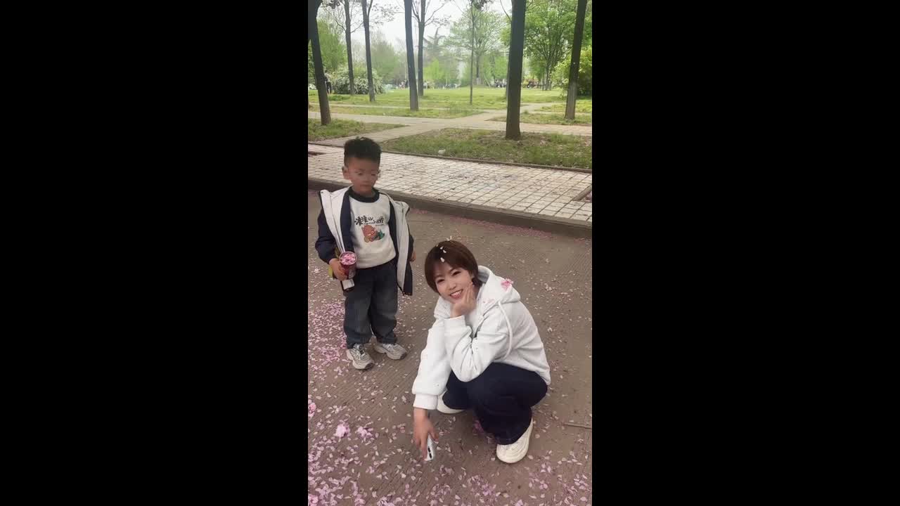Boy playfully pours flower petals on woman in Shaanxi, China