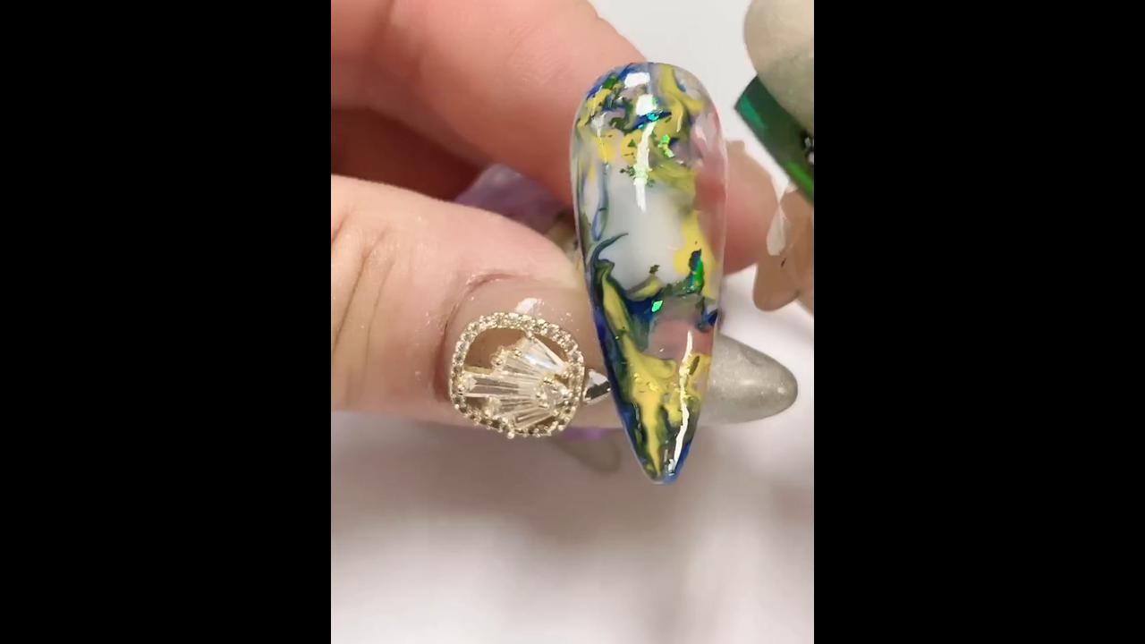 Designing transparent gel nails with green leaf foil and yellow ink ...