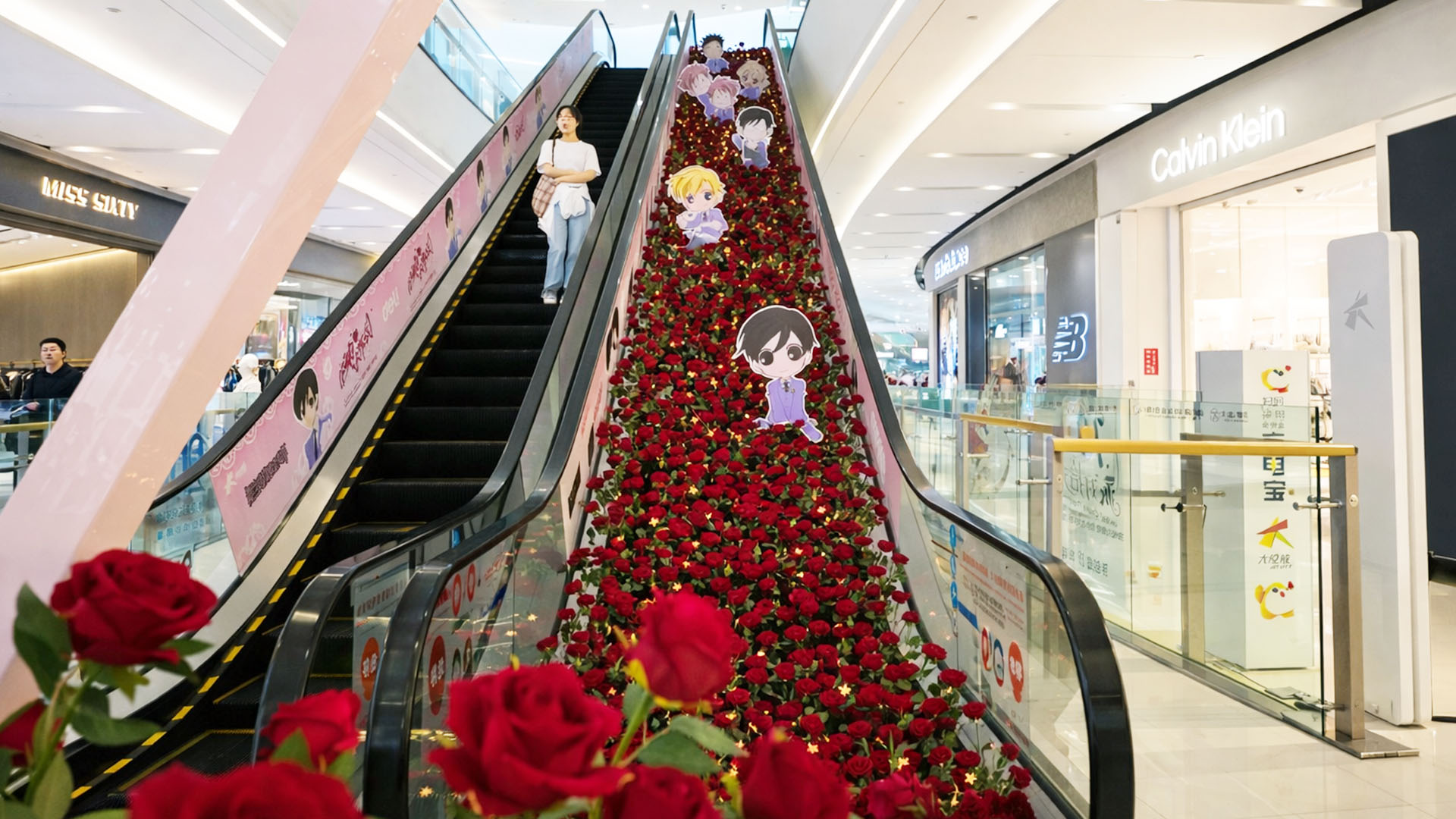 A rose path appears between escalators inside a busy China mall