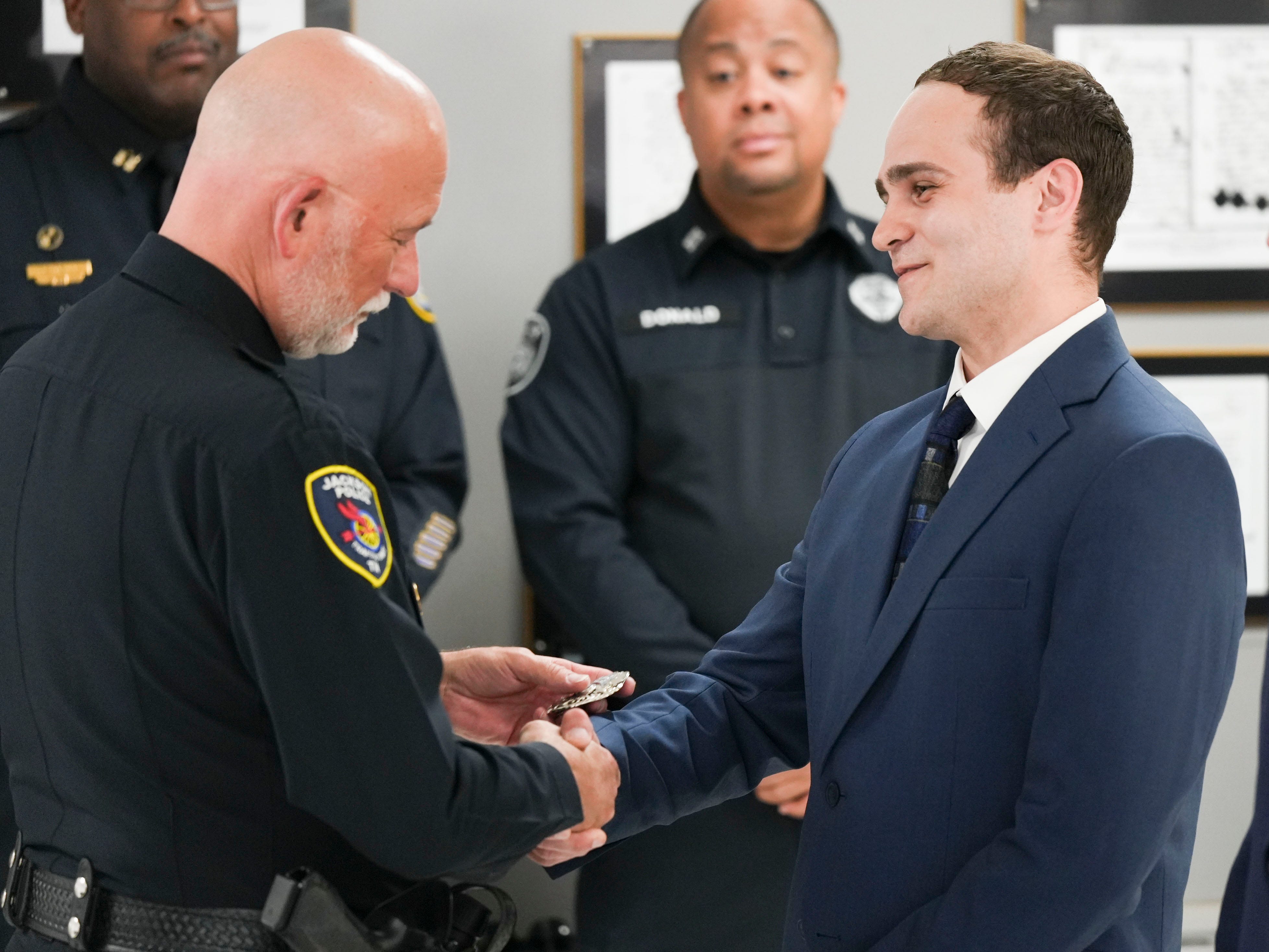 Jackson police retiring officer presents badge to son during swearing ...