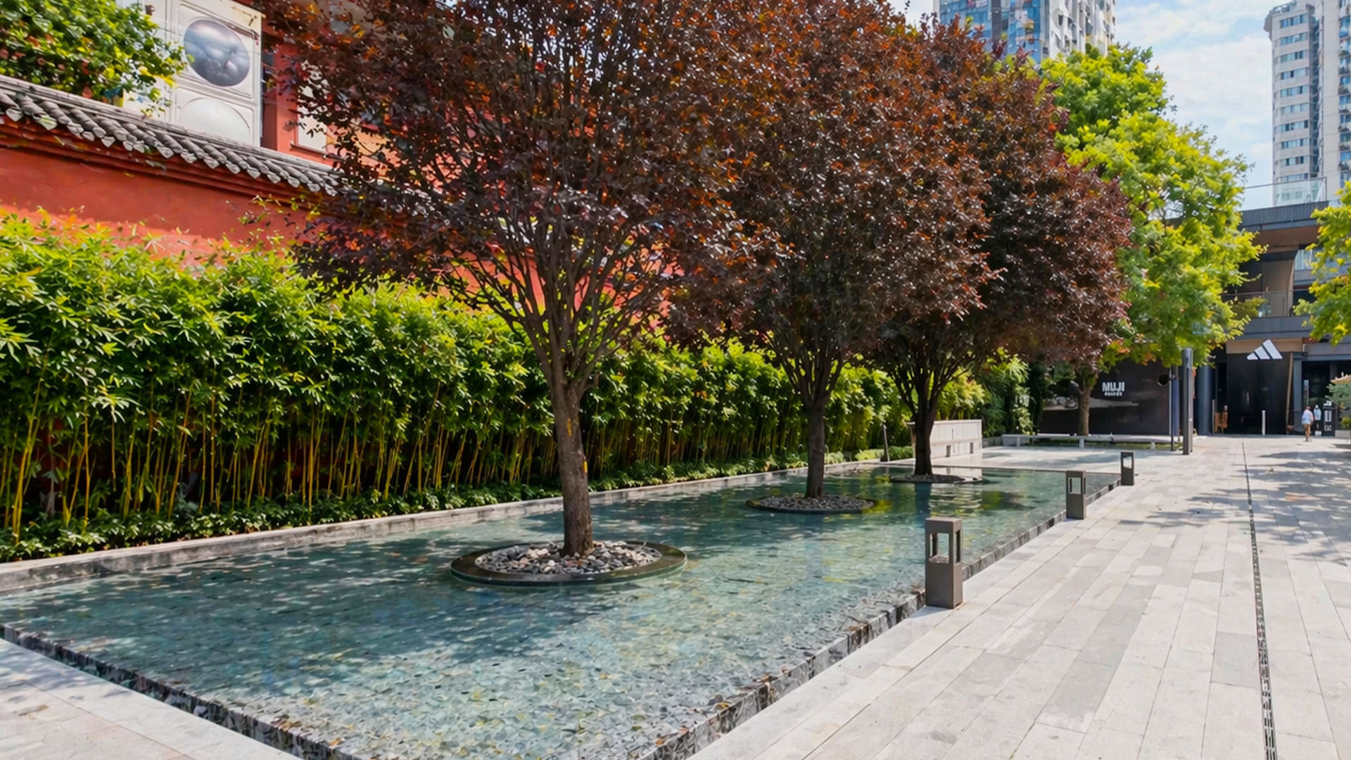 Een rustige hoek waar water en bomen contrasteren met winkelruimtes