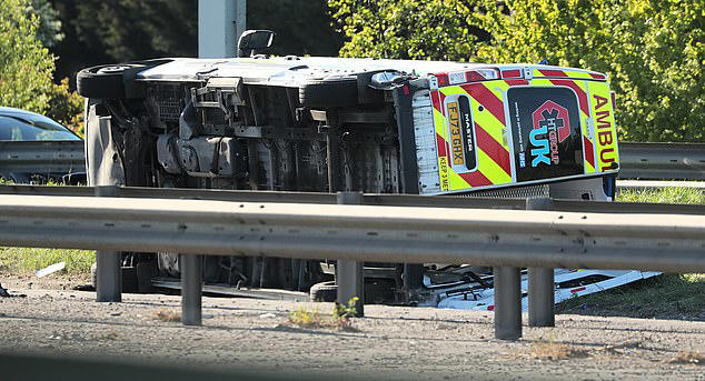 Woman arrested after ambulance flipped over in crash with car and lorry ...