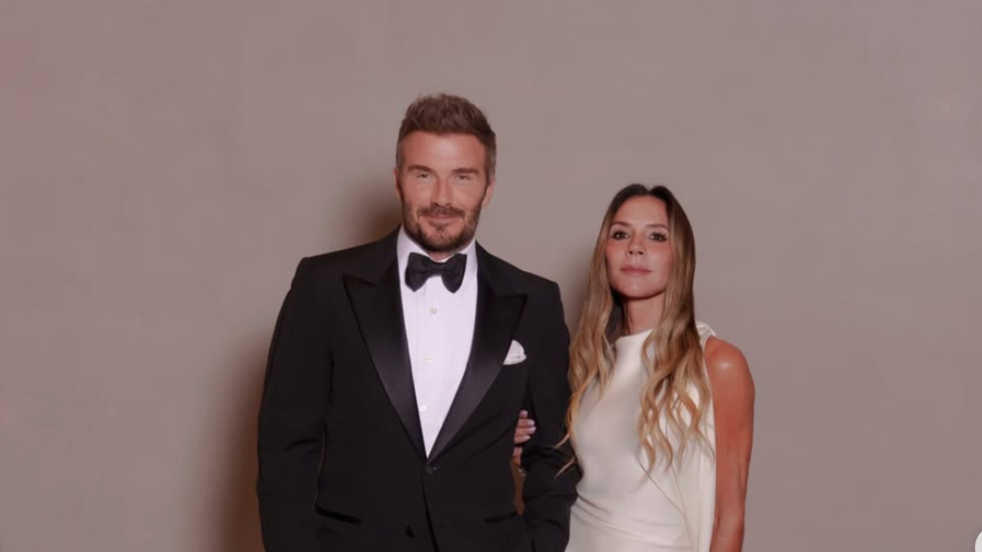 Victoria Beckham straalt in een witte satijnen jurk naast haar man