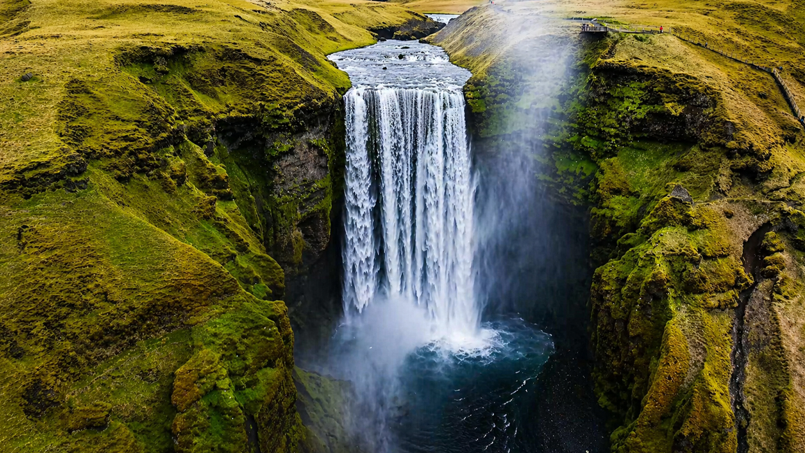Majestic waterfall cascading through lush green canyon