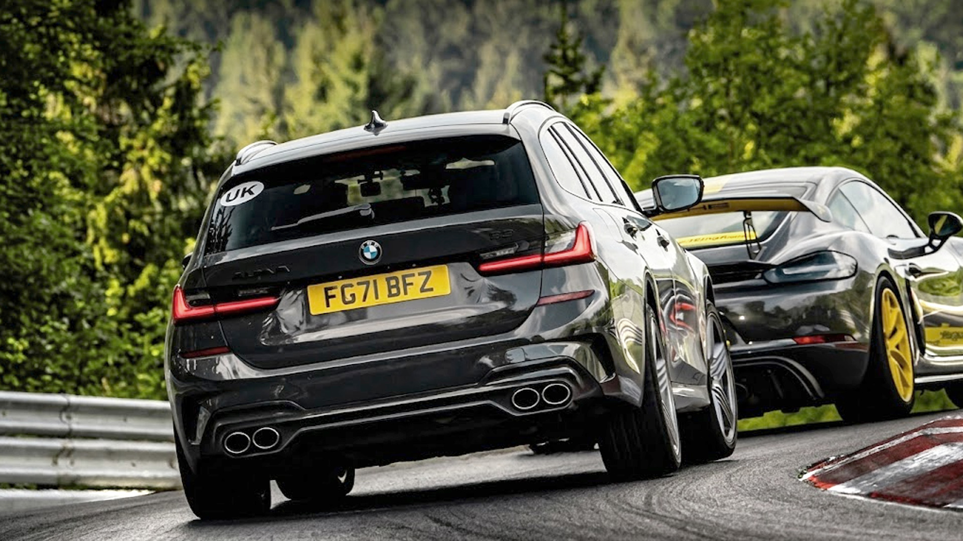 BMW wagon chasing a Porsche GT4 in a close gap battle