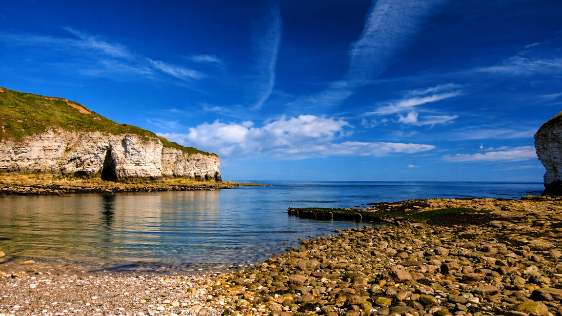 Crystal clear water along rocky coastline under blue sky