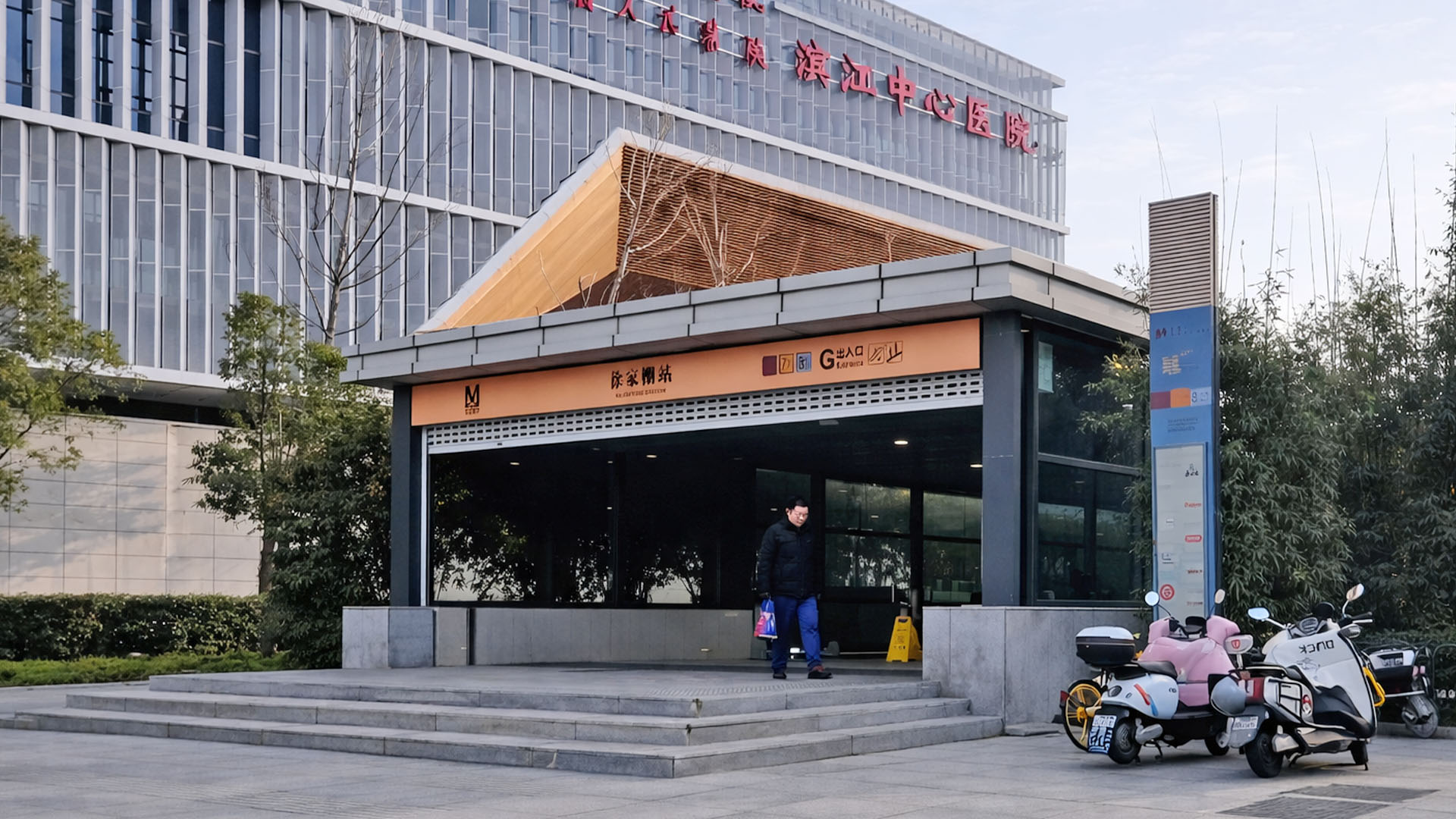 A low profile station entrance set below tall and modern structures