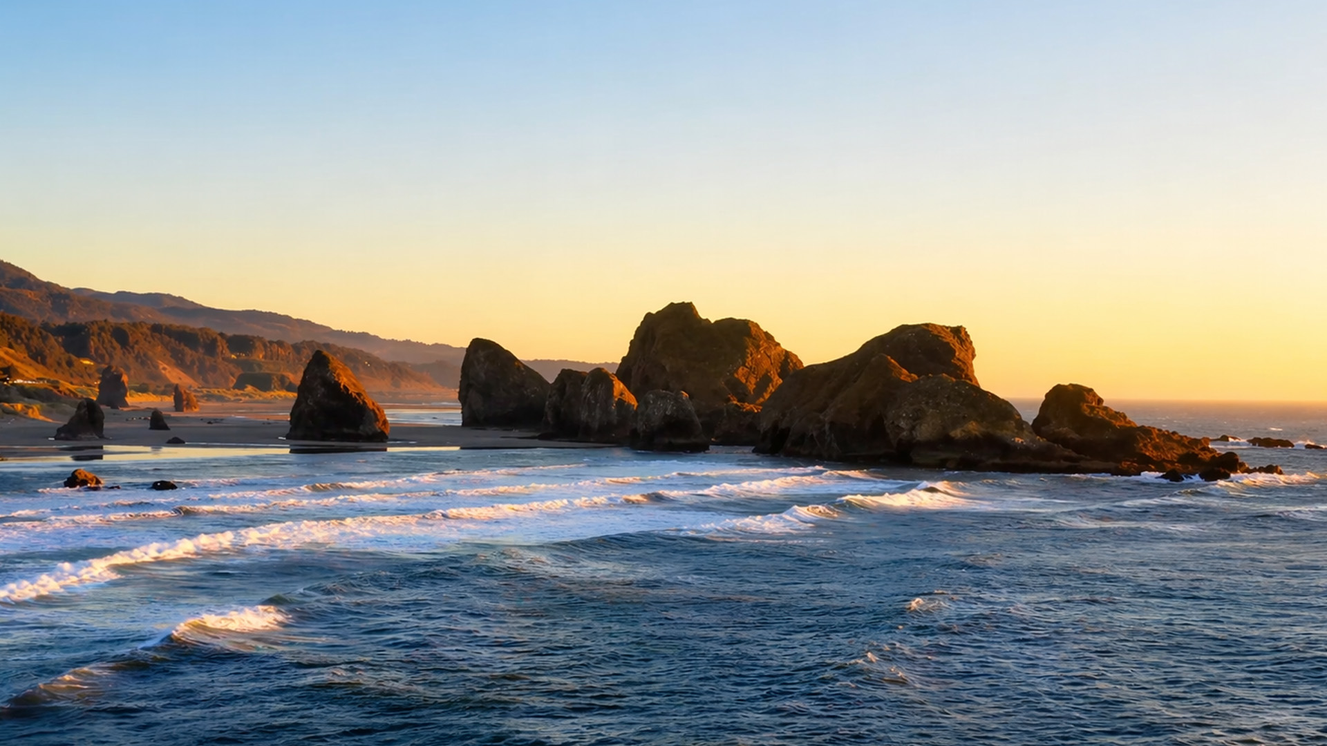 Ocean waves meet massive coastal rocks