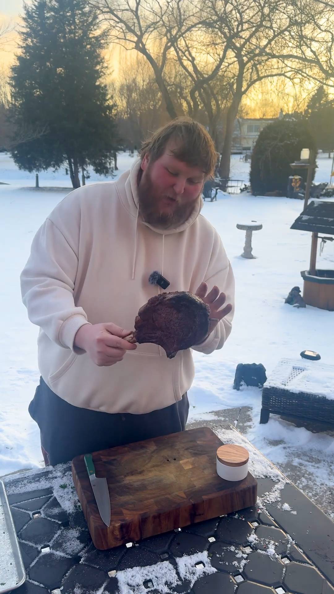 Winter outdoor cooking featuring a massive tomahawk ribeye steak grilled