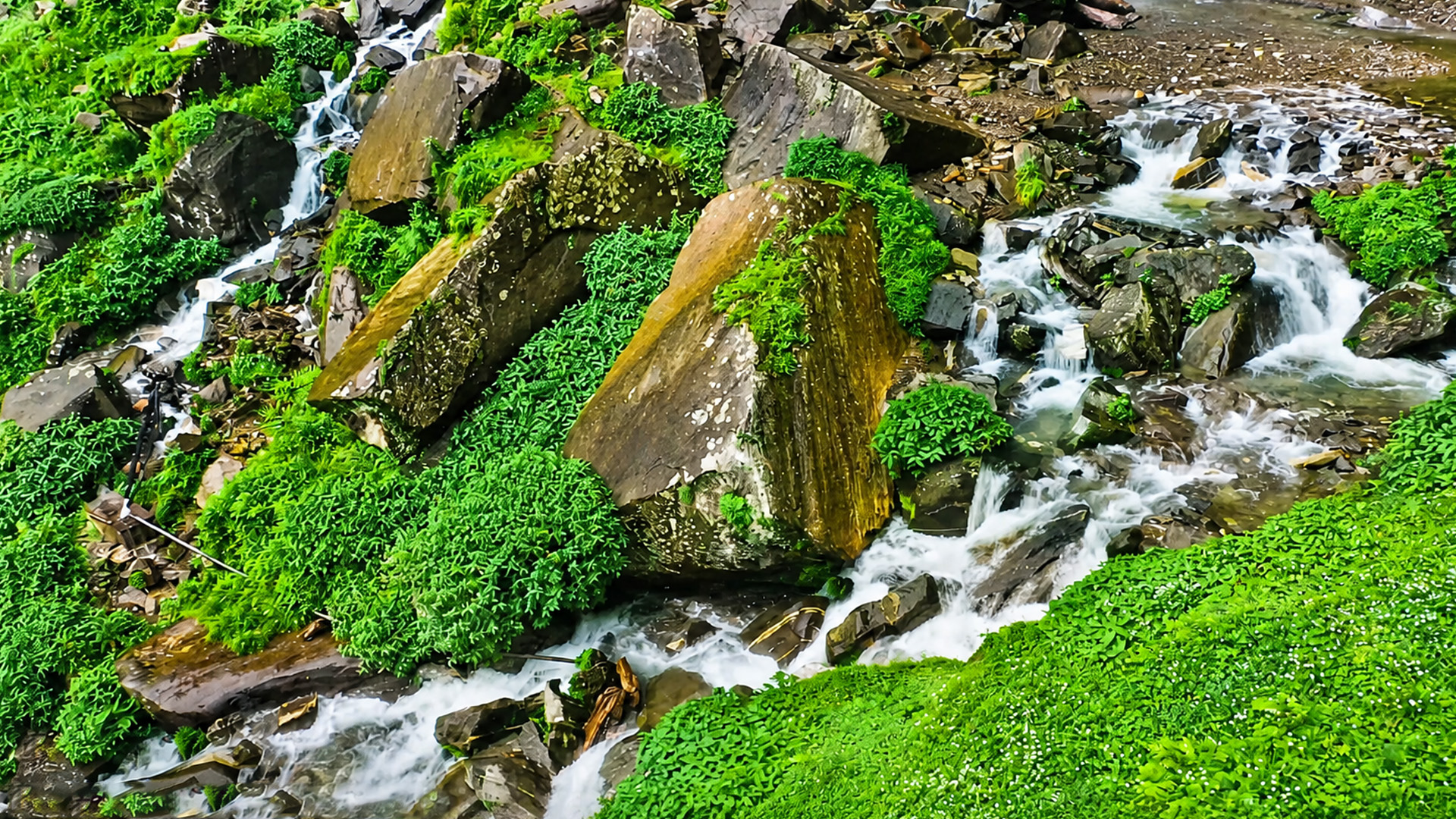 A refreshing mountain waterfall surrounded by lush green hills