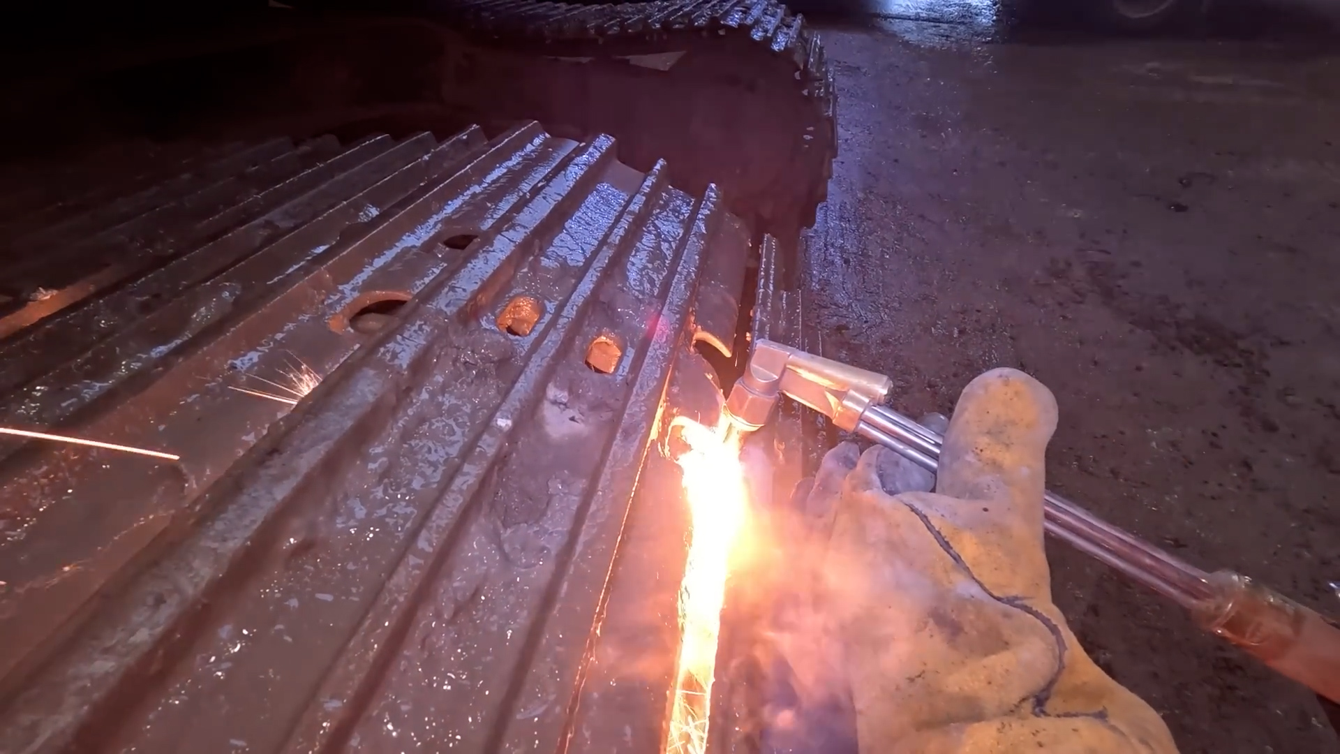 Thermal cutting worn excavator track components at night