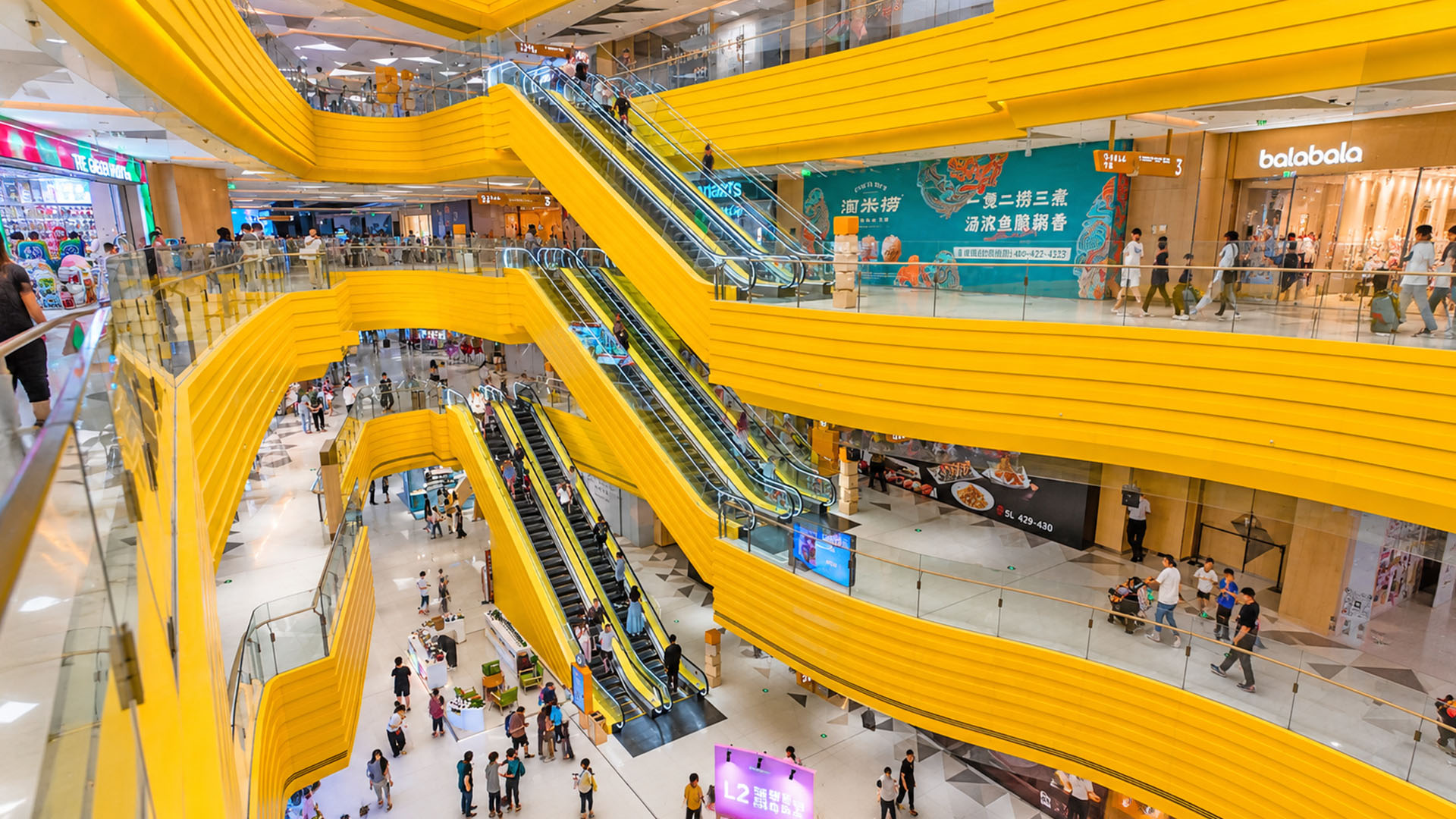 Jasně žluté víceúrovňové obchodní centrum vytváří moderní nákupní atmosféru